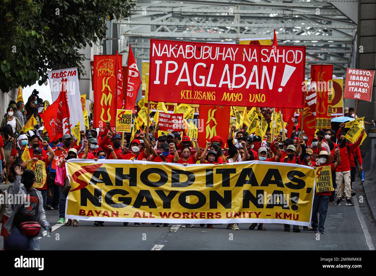 Workers carrying banners during a labor protest march on Bonifacio Day ...