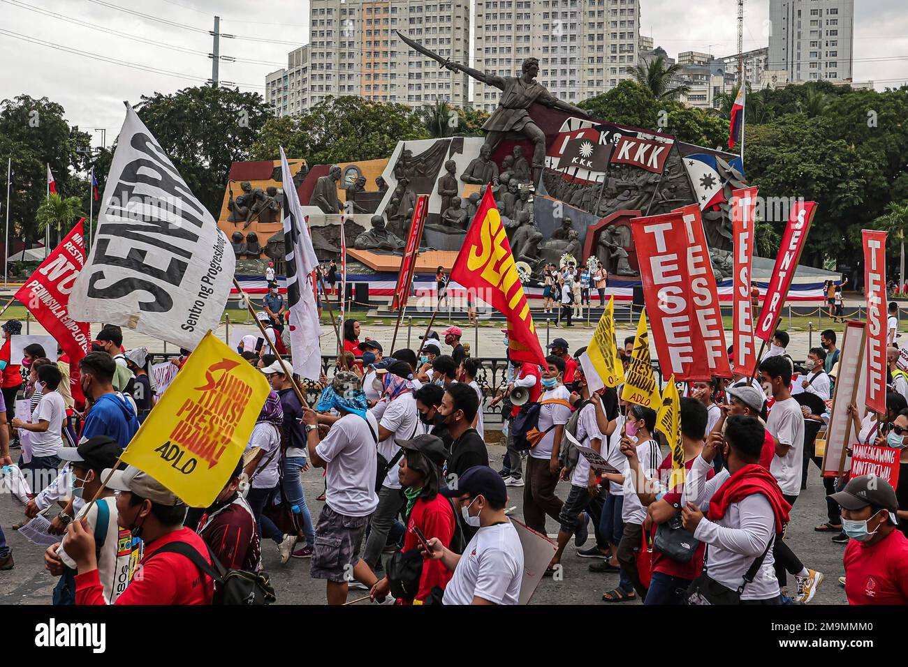 Workers walk past the Bonifacio Monument during a labor march on ...