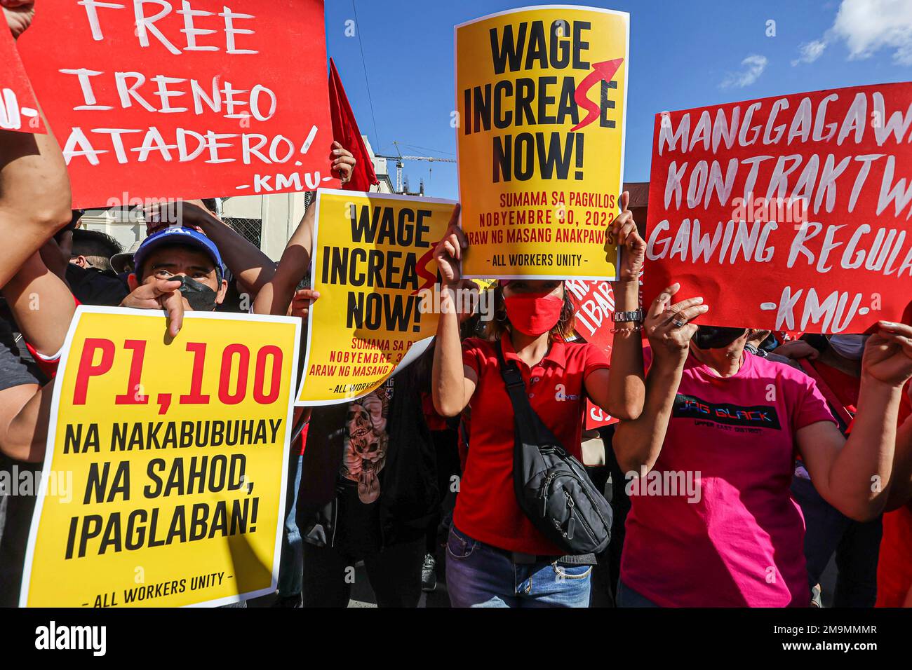 Workers raise placards during a labor march on Bonifacio Day, Wednesday ...