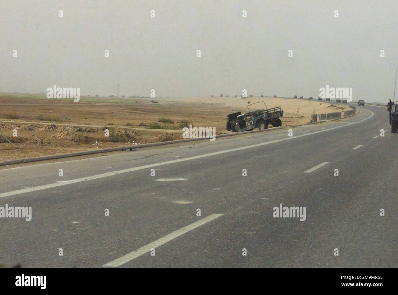 United States Marine Corps (USMC) military vehicles convoy down a road ...