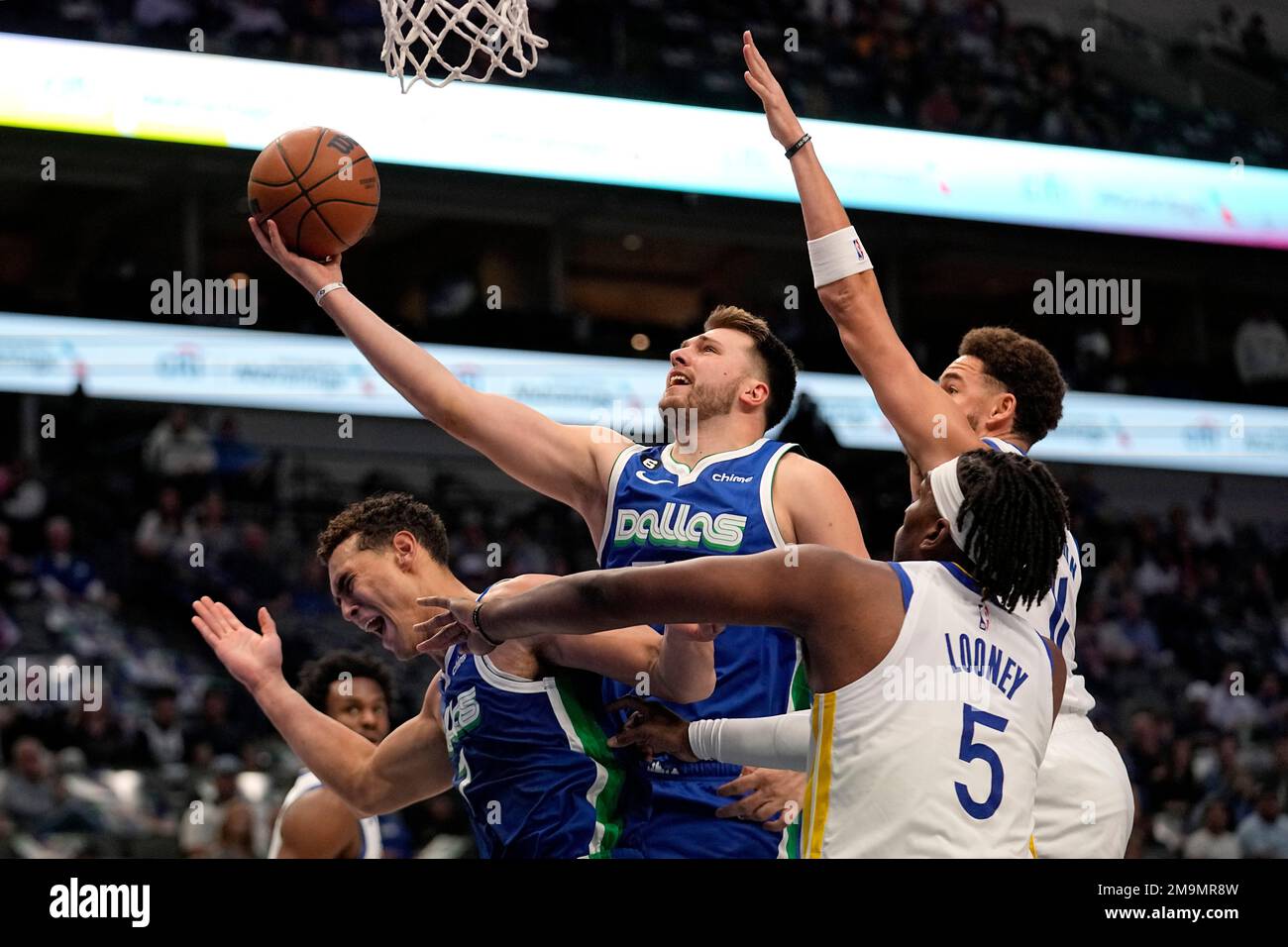Dallas Mavericks guard Luka Doncic goes up for a shot over teammate Dwight Powell, left, as ...