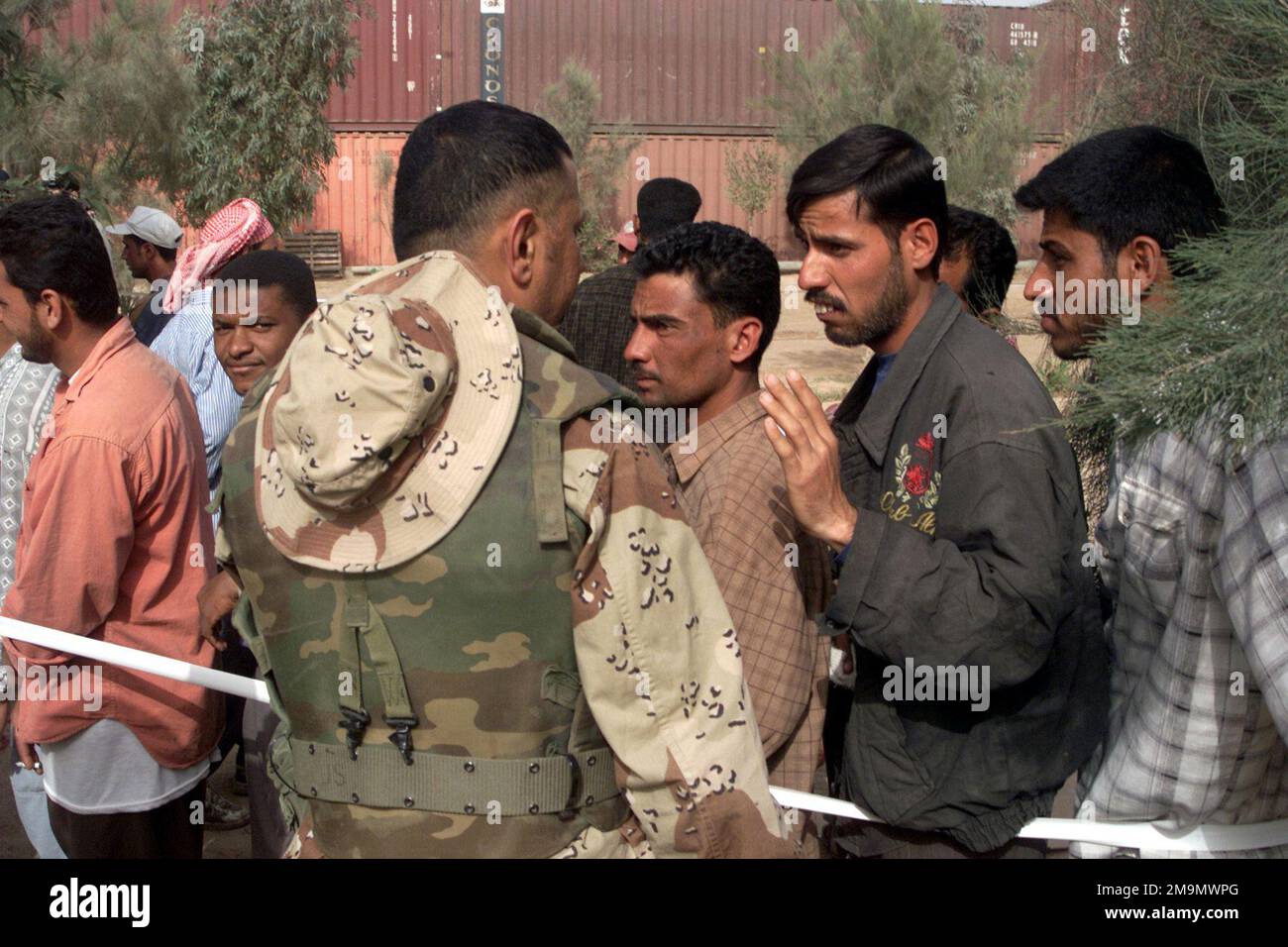 An unidentified Free Iraqi Forces (FIF) Soldier talks with local Iraqi ...
