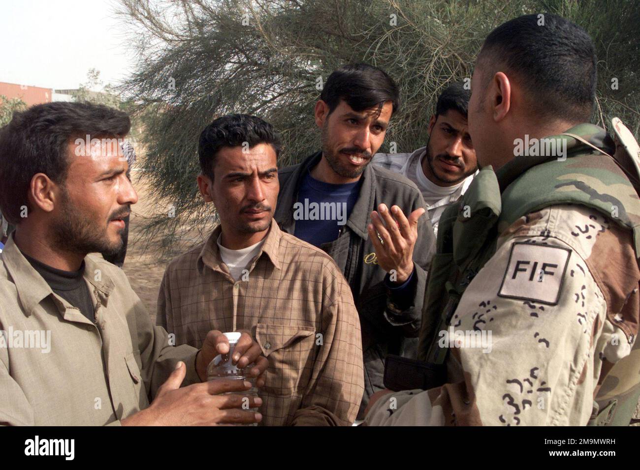 An unidentified Free Iraqi Forces (FIF) Soldier talks with local Iraqi ...