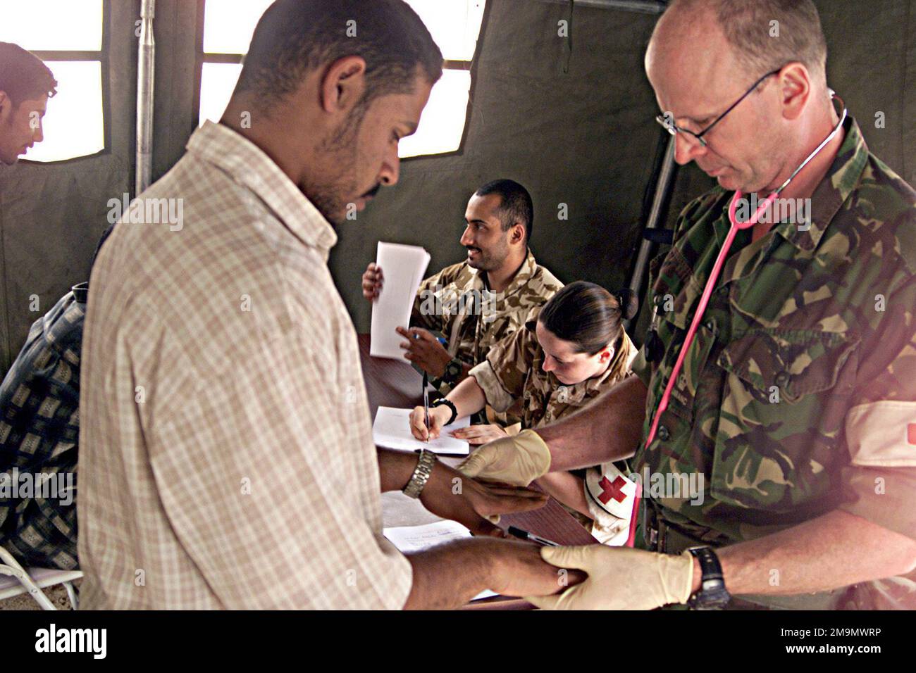 A British Army (UK) Medical Doctor examines the hands of a local Iraqi ...