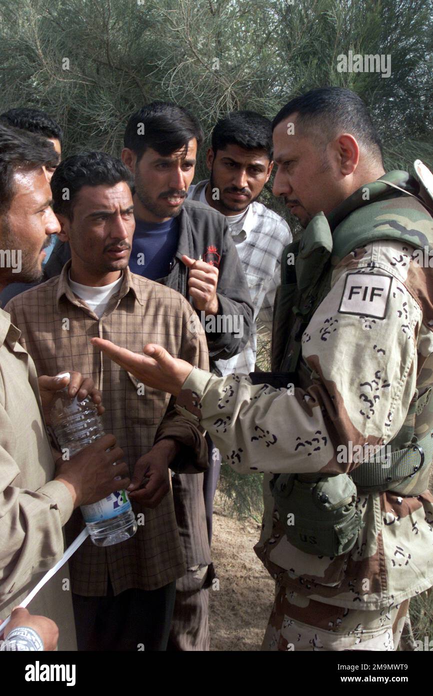 An unidentified Free Iraqi Forces (FIF) Soldier talks with local Iraqi ...