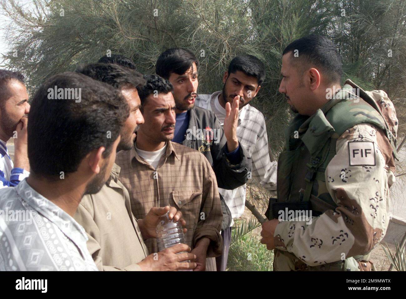 An unidentified Free Iraqi Forces (FIF) Soldier talks with local Iraqi ...