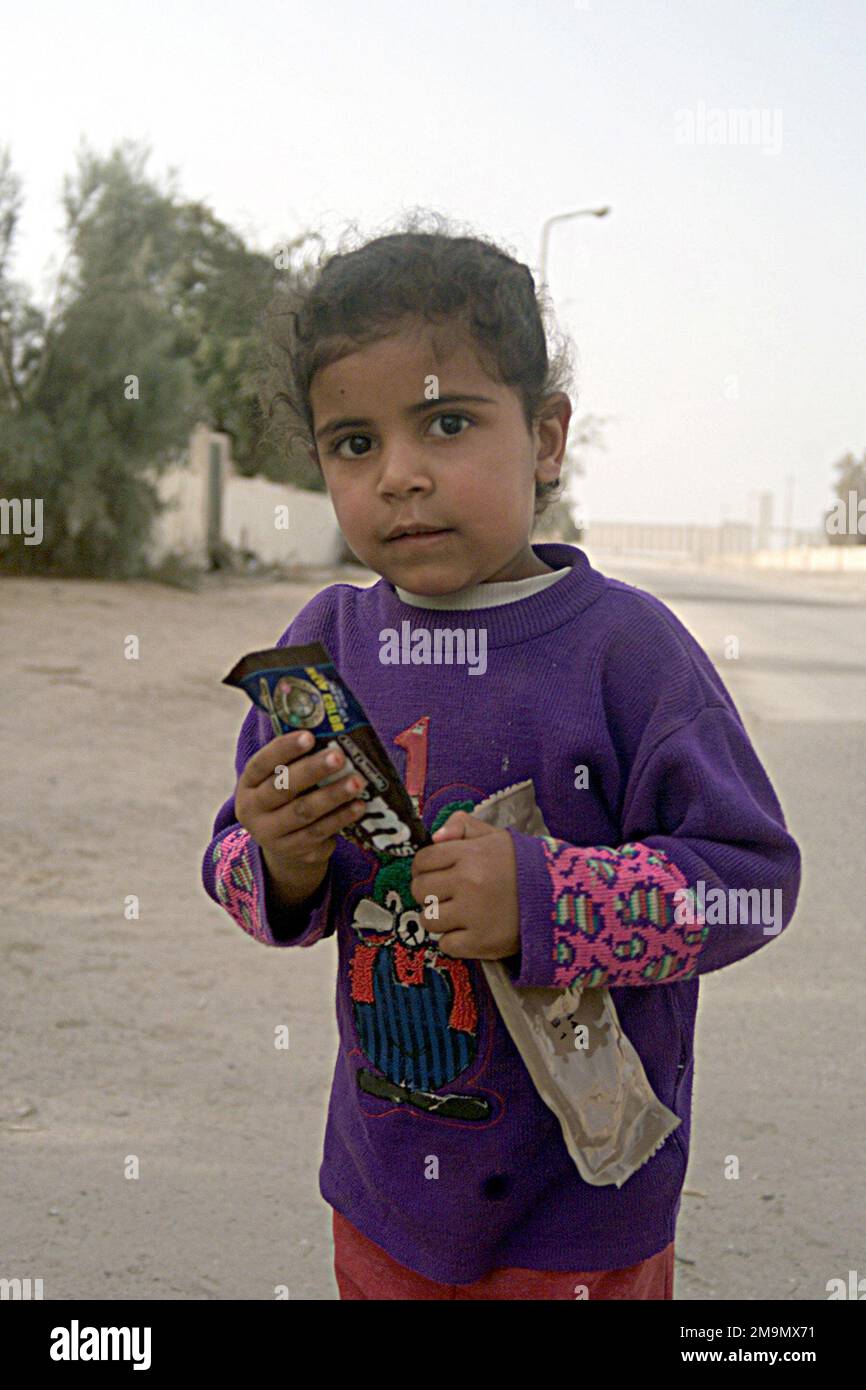 A small Iraqi girl poses for a photograph after receiving candy from ...