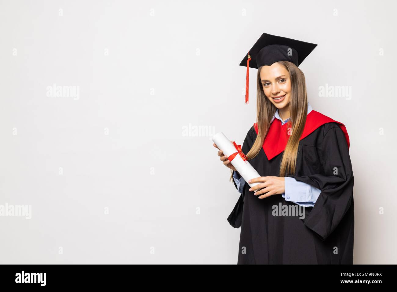 Beautiful woman college graduate portrait wearing cap and gown with ...