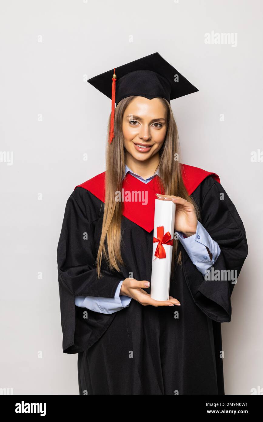 Beautiful woman college graduate portrait wearing cap and gown with ...