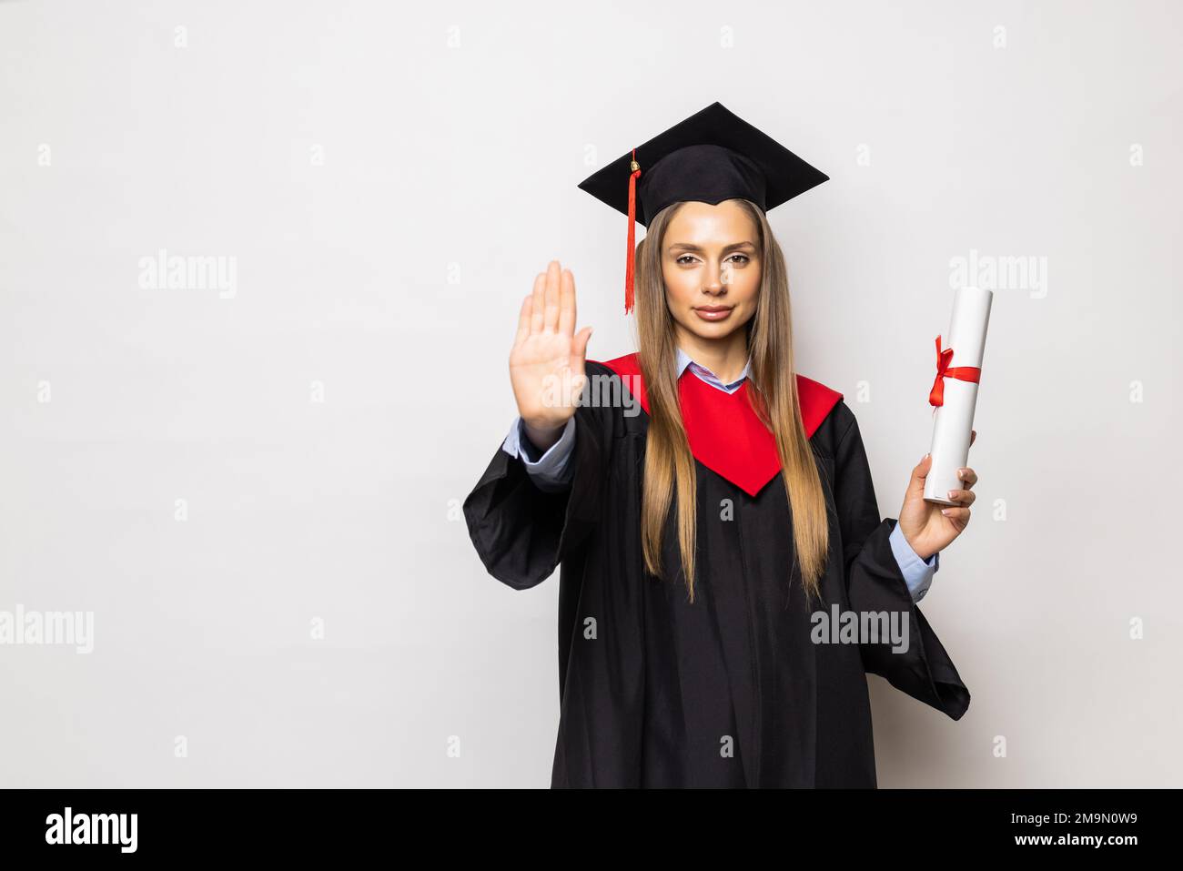 Beautiful woman college graduate portrait wearing cap and gown with ...