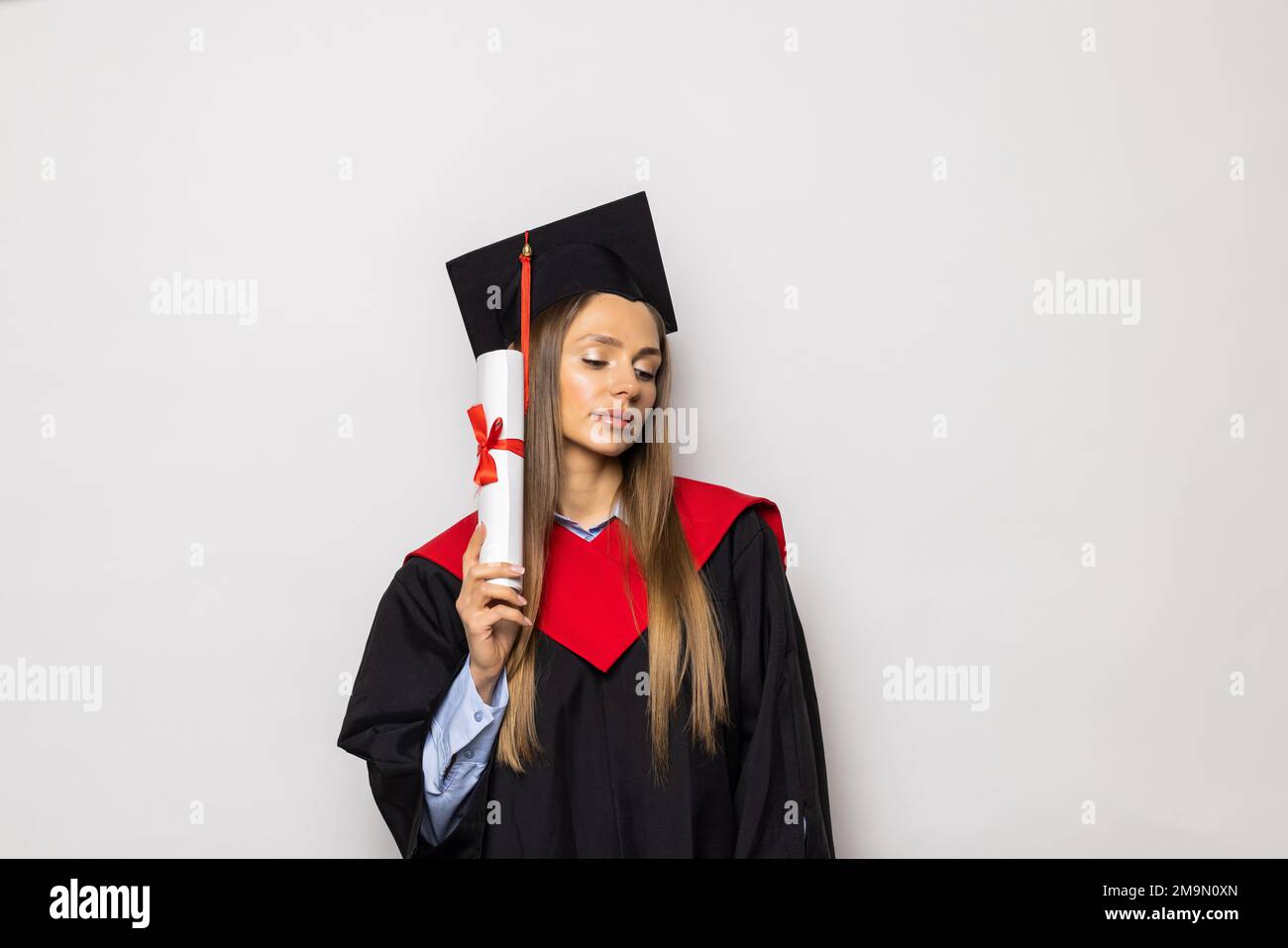 Young graduate girl student in mantle with diploma, isolated on white ...
