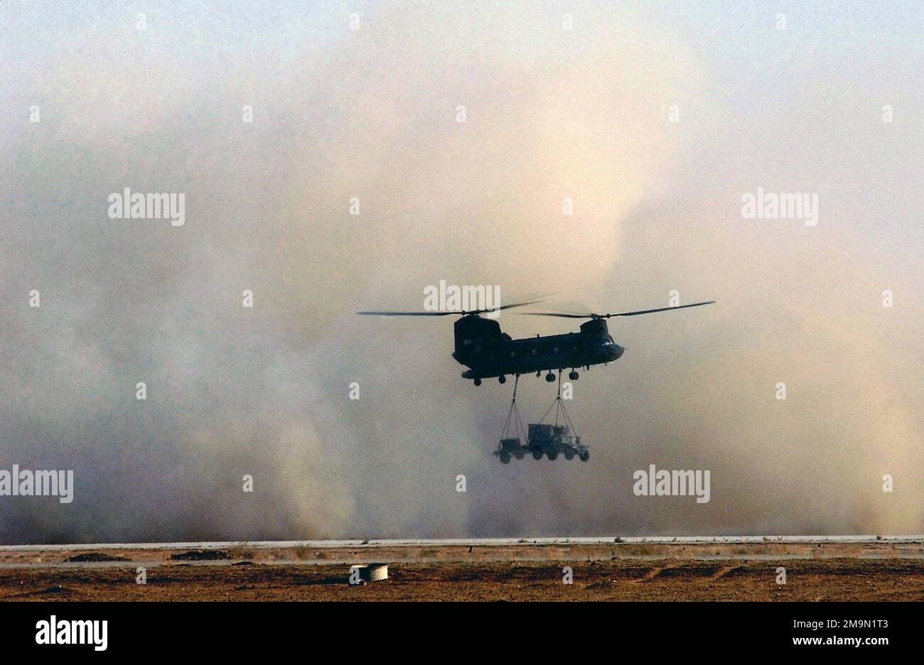 A US Army (USA) CH-46 Chinook helicopter lifts a USA vehicle to an ...