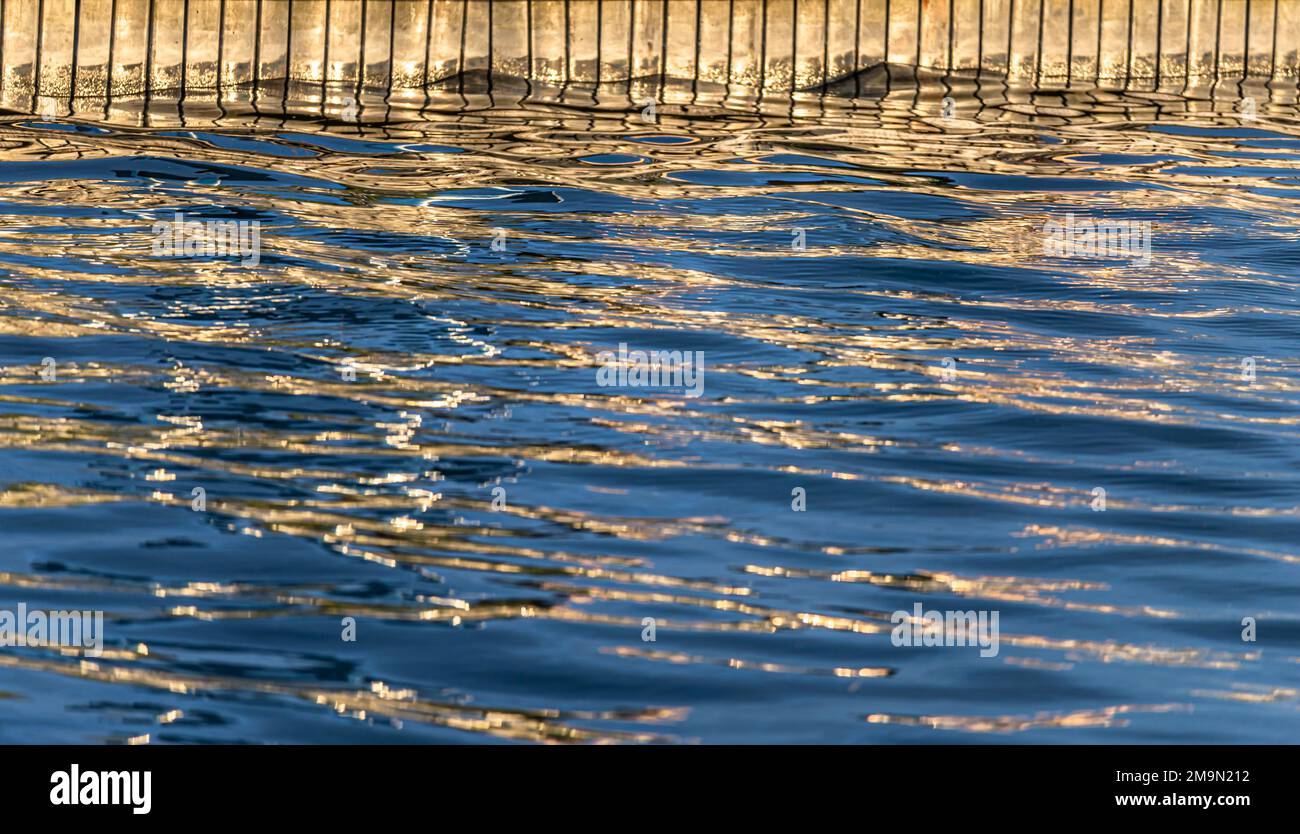 Reflections of sunset in the waves of a river Stock Photo - Alamy