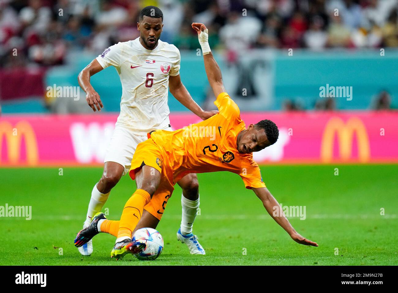 Jurrien Timber of the Netherlands falls challenged by Qatar's Abdulaziz Hatem during a World Cup ...