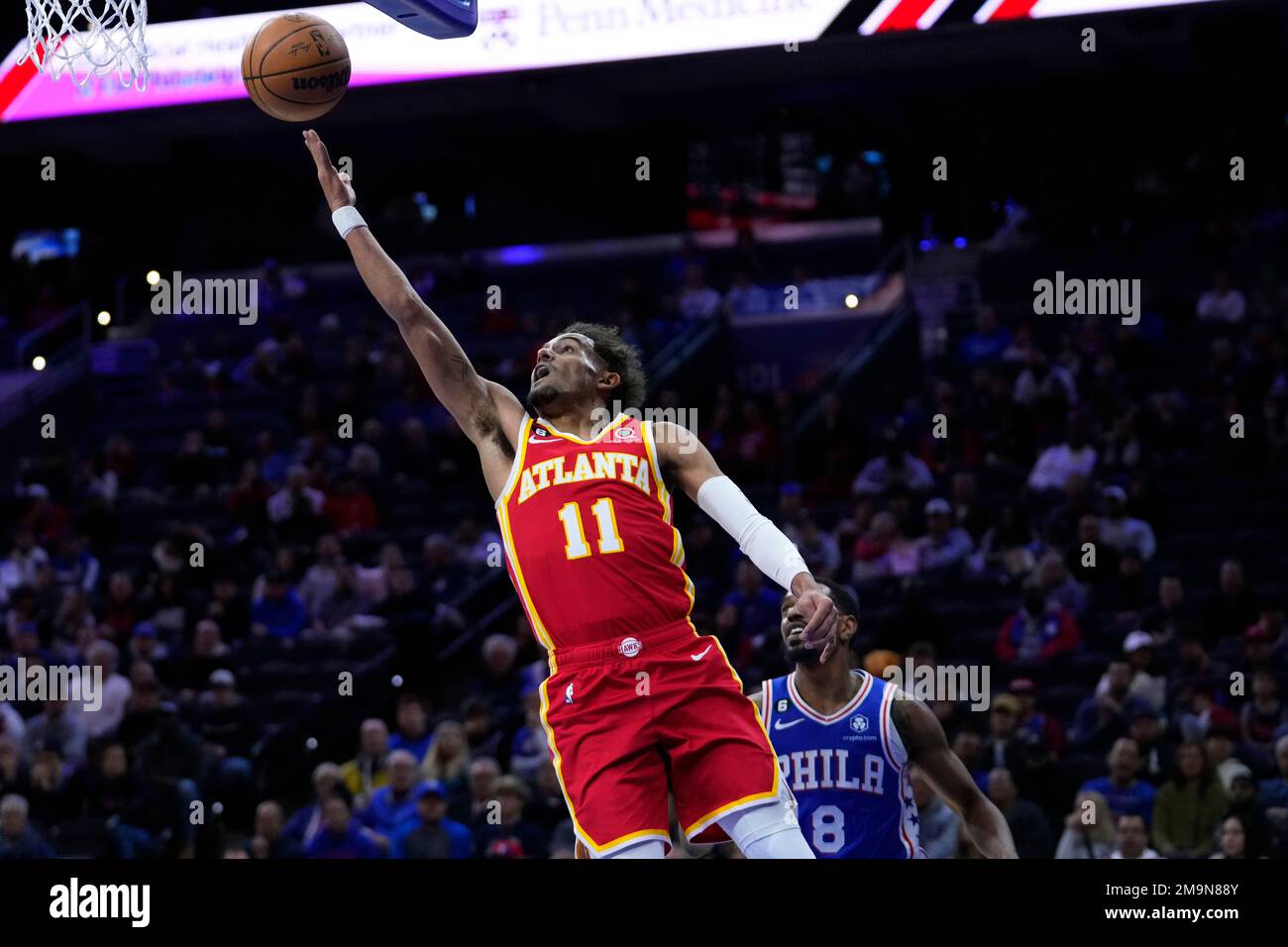 Atlanta Hawks' Trae Young, left, goes up for a shot past Philadelphia ...