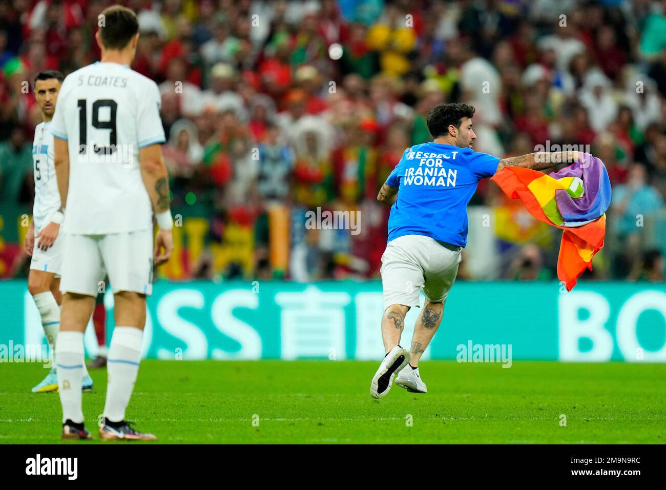A pitch invader runs across the field with a rainbow flag during the ...