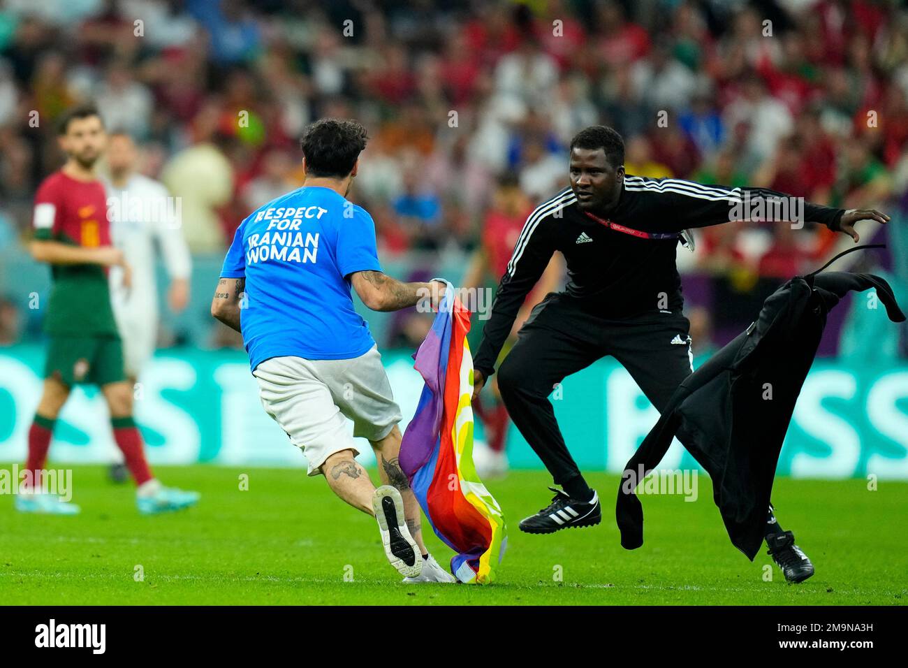 A pitch invader runs across the field with a rainbow flag during the ...