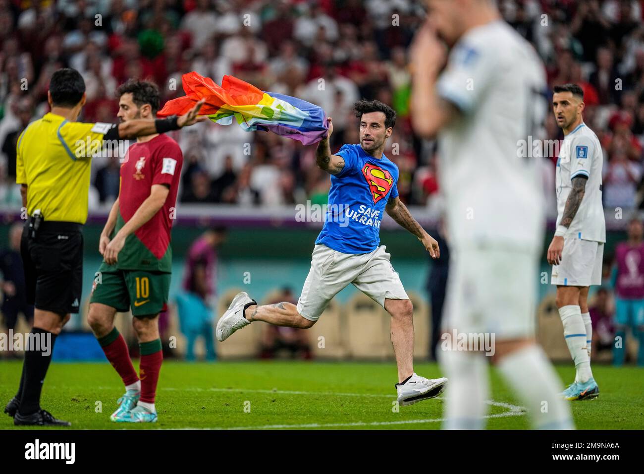 A pitch invader runs across the field with a rainbow flag during the ...