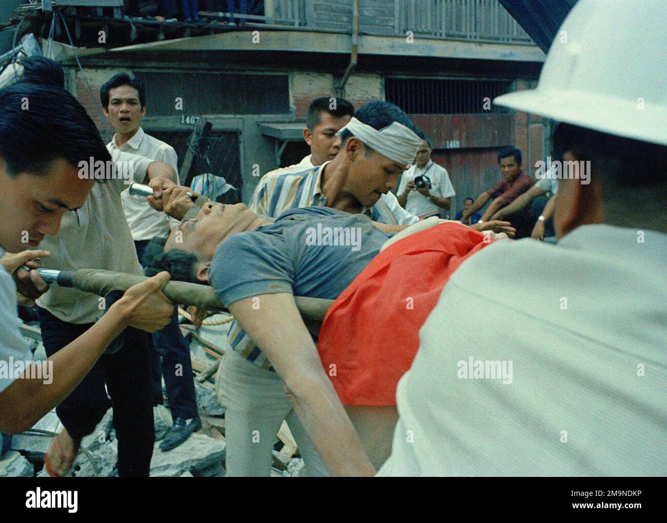 Rescuers carry an earthquake victim on a stretcher out of a collapsed ...