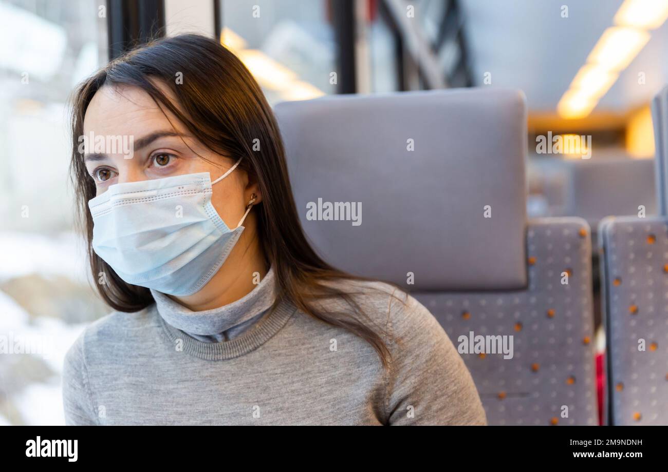 Woman in mask sitting on her seat while traveling by train Stock Photo ...