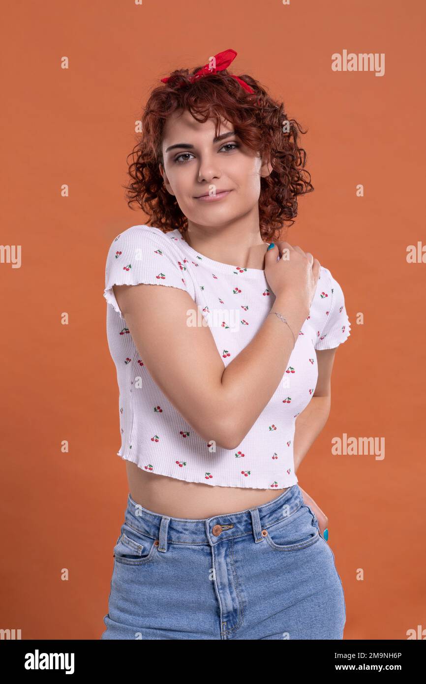 A gentle smile on the face of a young European woman with curly hair ...