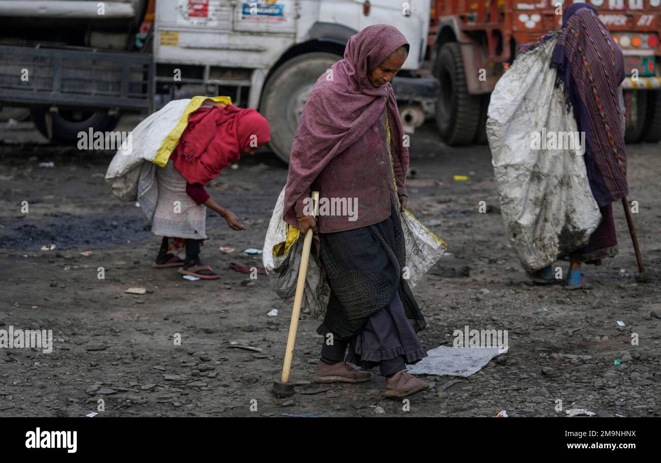 Rag picker women walk with rods fitted with magnets as they look for ...