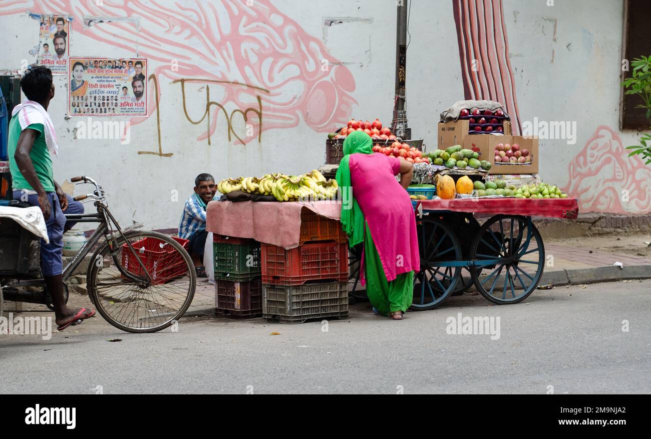 Indian trader selling fruits and vegetable in the street on a carriage ...