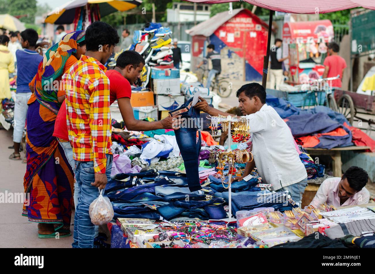 Indian people buying clothes at bazaar outdoor. Street market downtown ...
