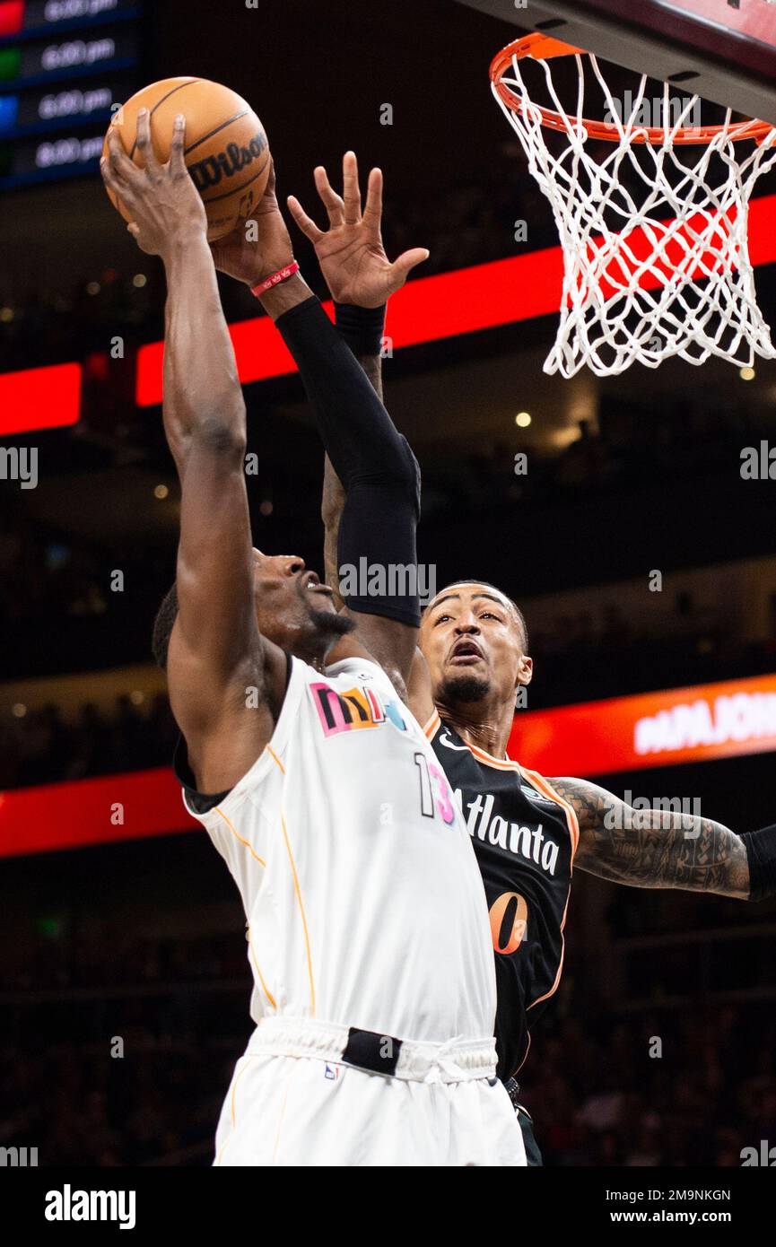 Miami Heat center Bam Adebayo shoots against Atlanta Hawks forward John Collins during the ...