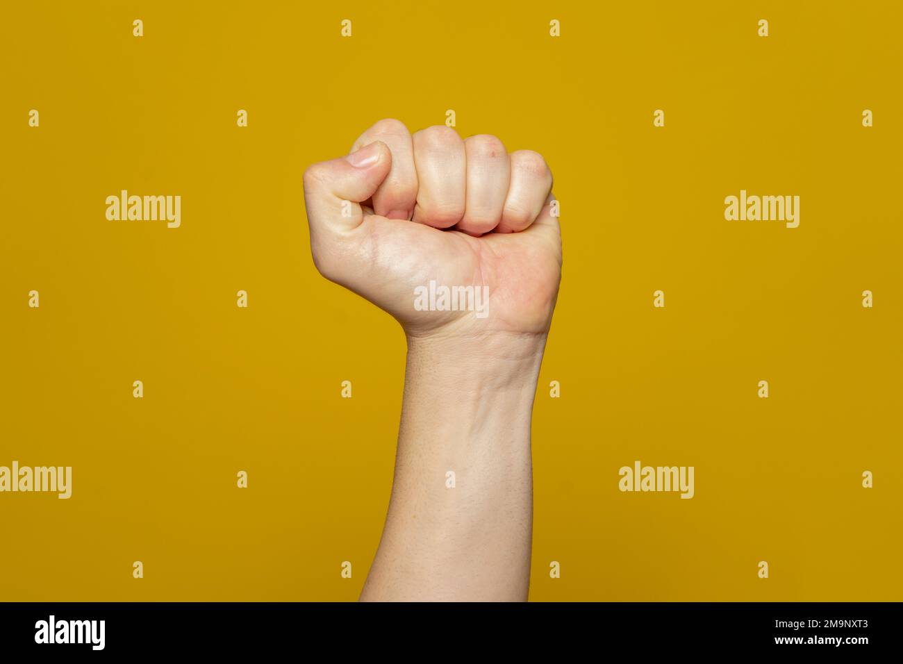 Male clenched fist, isolated on an orange background. Strong man's hand ...