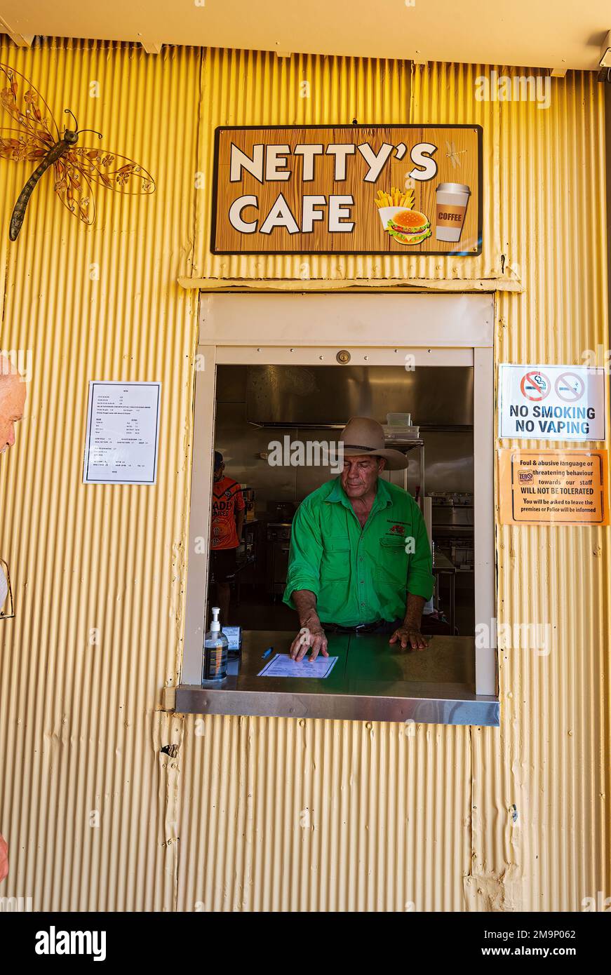 Waiter at the food serving window of the old historic Kalkadoon Hotel ...