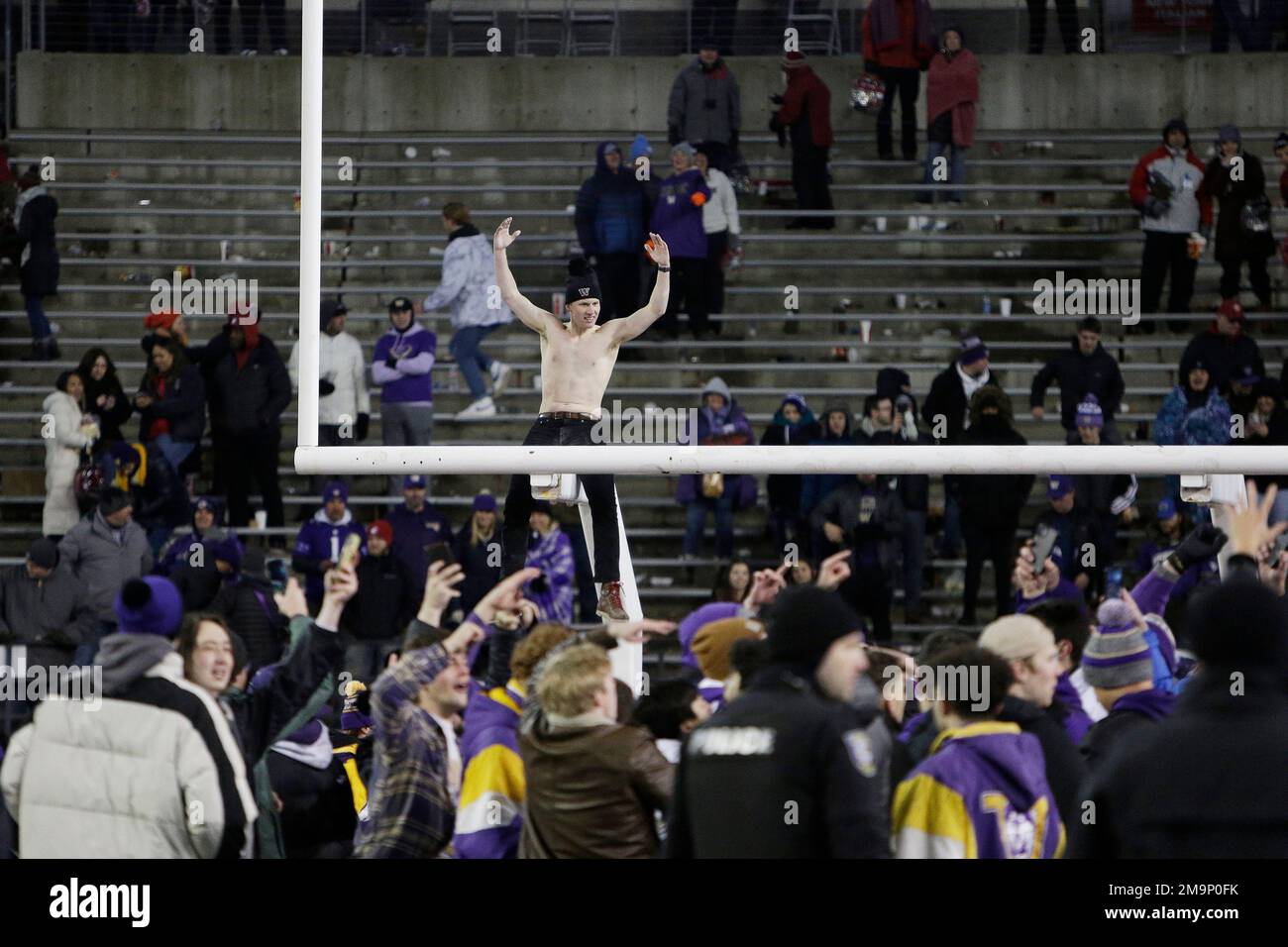 Washington fans, including one on a goal post, celebrate on the field ...