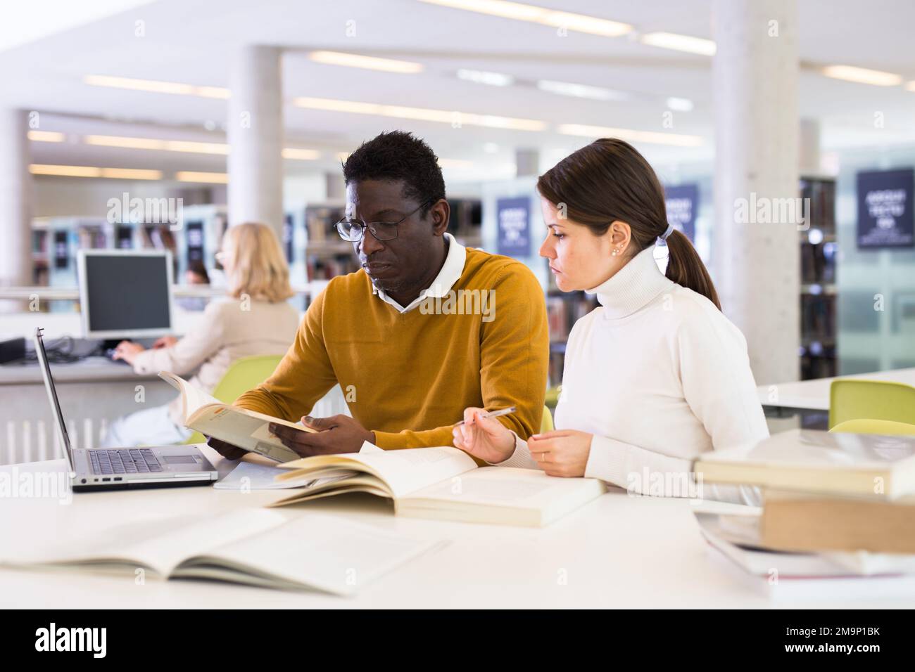 Female student with a book in a public library hi-res stock photography ...