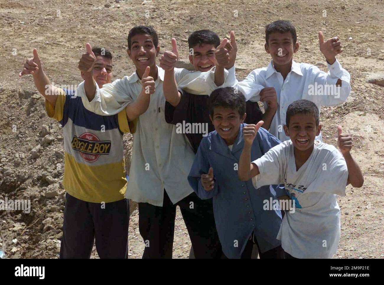 A group of local Iraqi children pose for photograph along the side of a ...