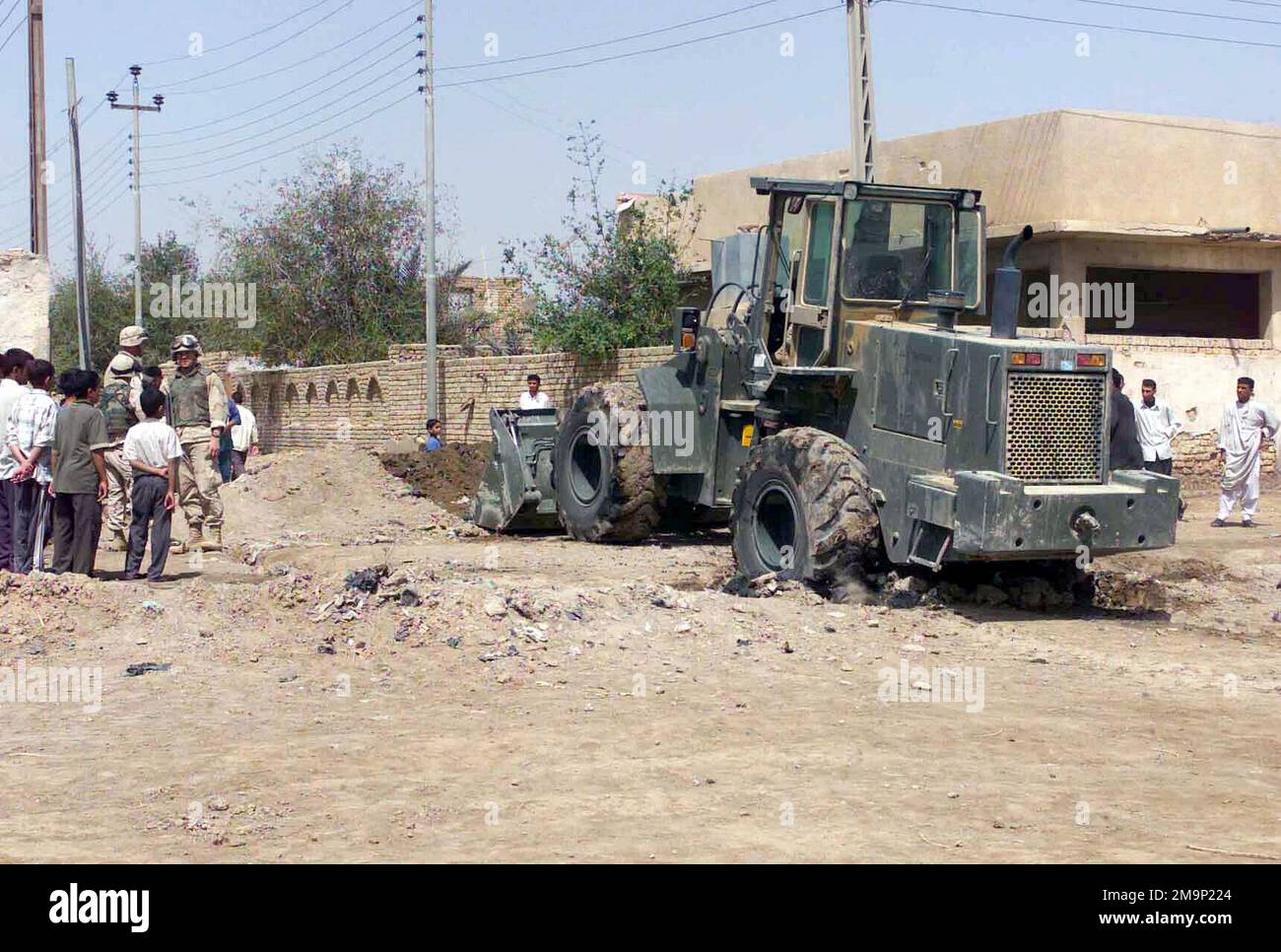 Local Iraqi civilians gather and watch as US Marine Corps (USMC ...