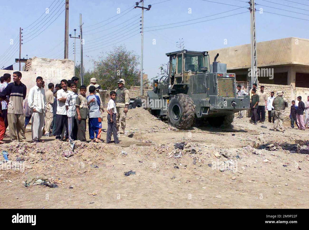 Local Iraqi civilians gather and watch as US Marine Corps (USMC ...