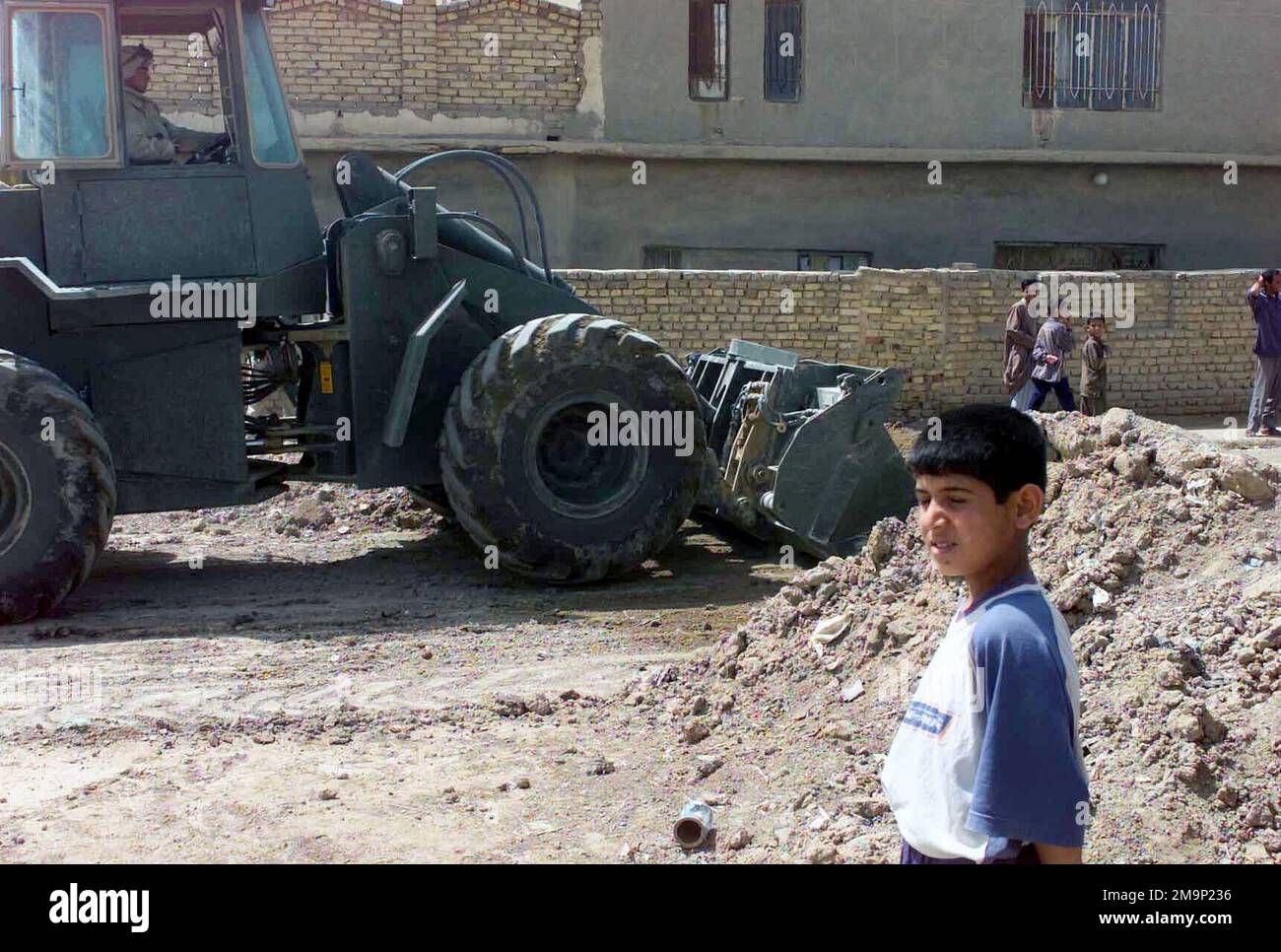 Several local Iraqi children gather and watch as a US Marine Corps ...