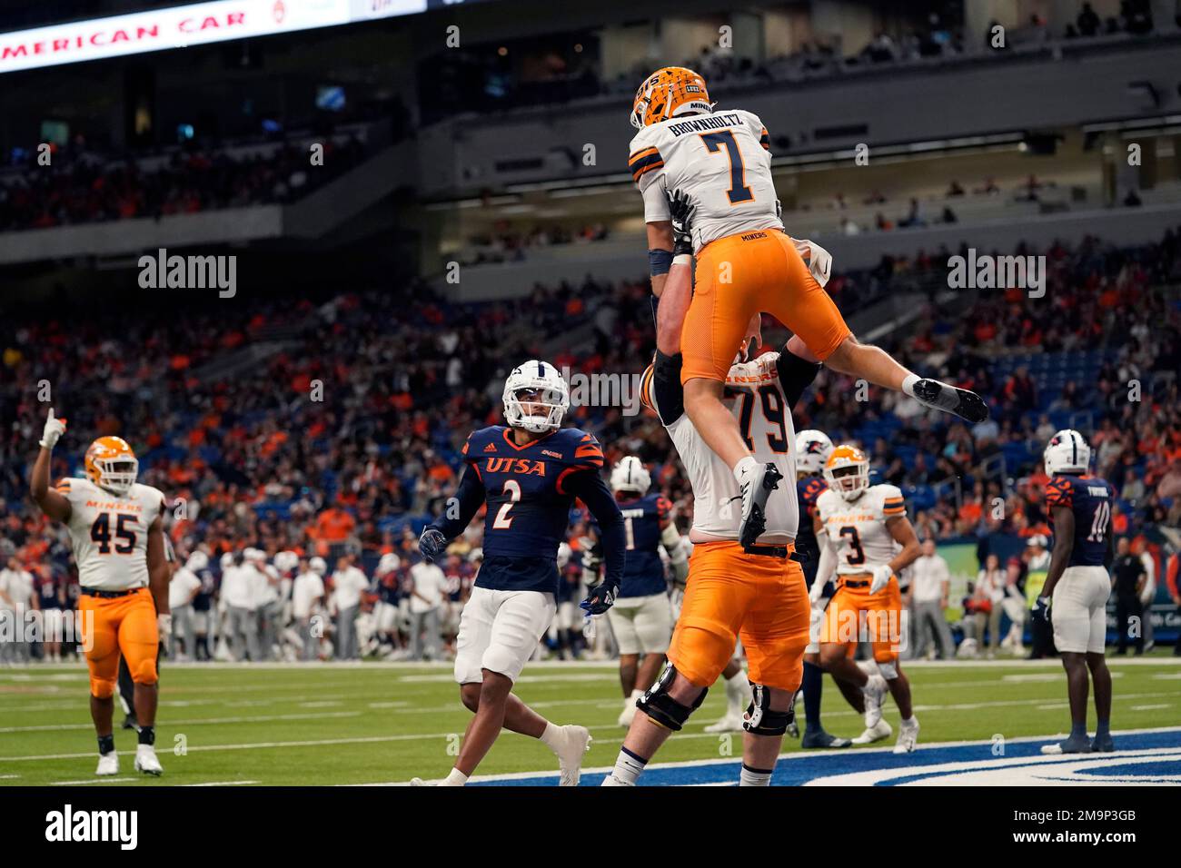 UTEP quarterback Calvin Brownholtz (7) is lifted by teammate Elijah ...