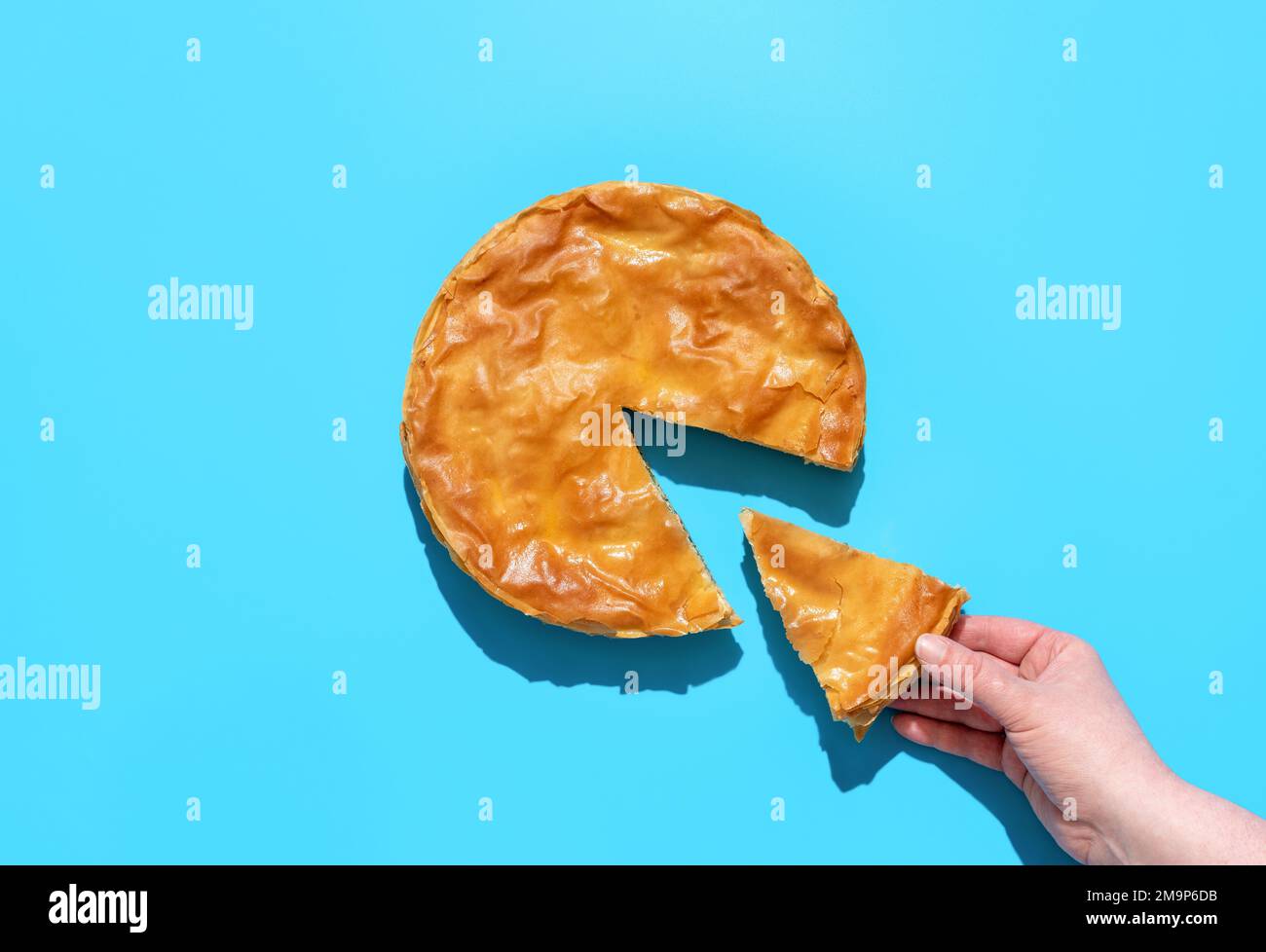 Above view with a phyllo pastry cake, filled with feta cheese and ...