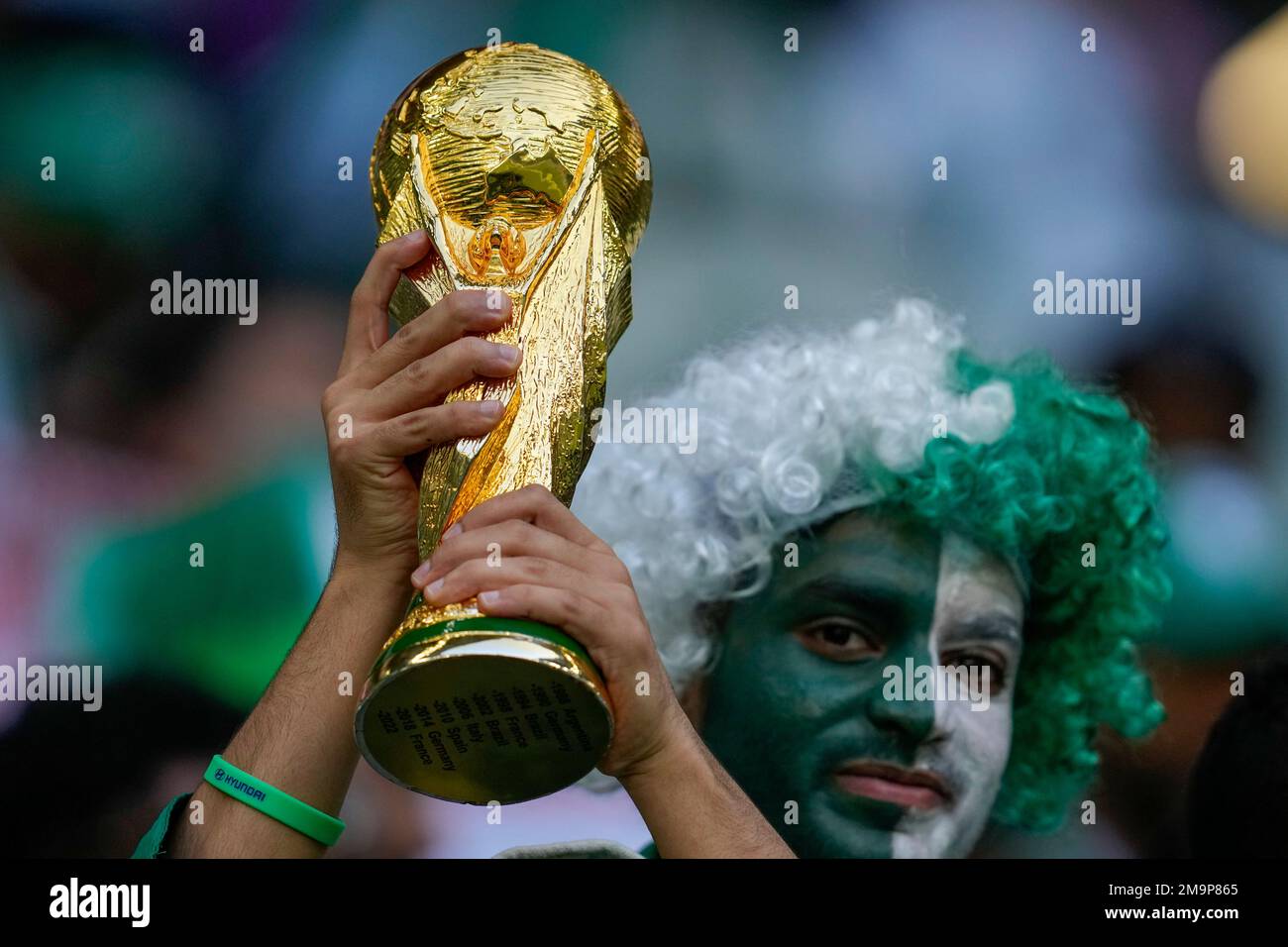 A Saudi Arabia's soccer team supporter holds up a small replica of the ...