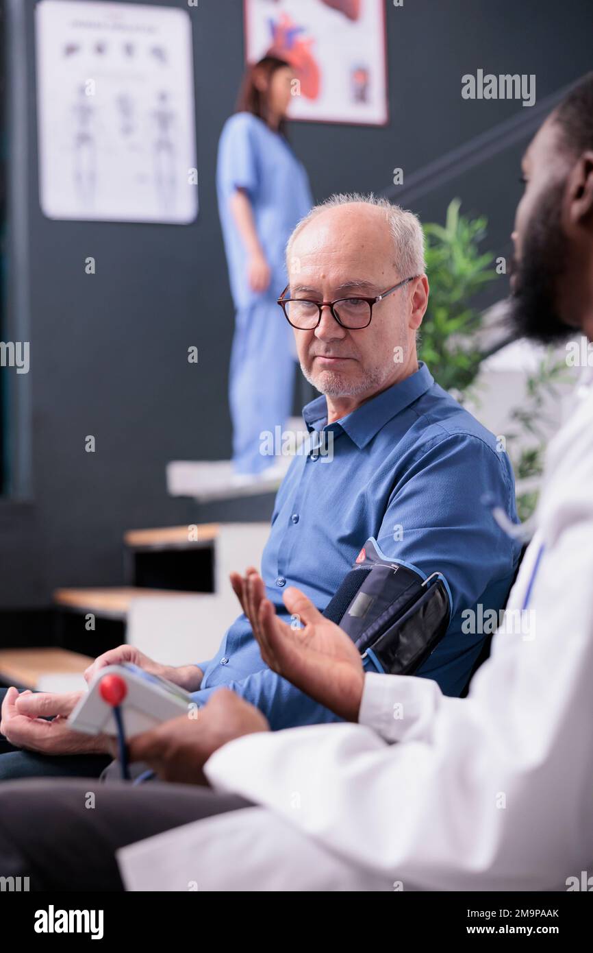 African american cardiologist using tonometer instrument to measure ...