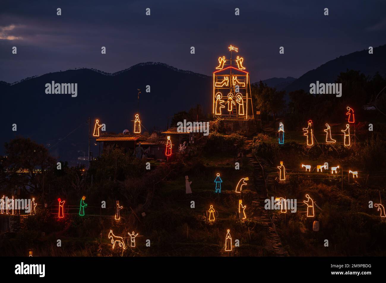 Illuminated Nativity Scene on the top of a Hill over the village of ...