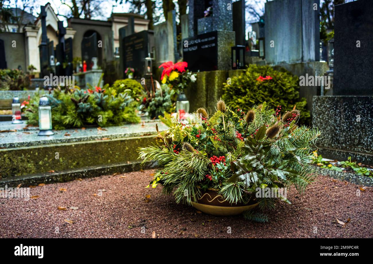 Flower arrangement and funeral wreath at grave in cemetery. Tombstones ...