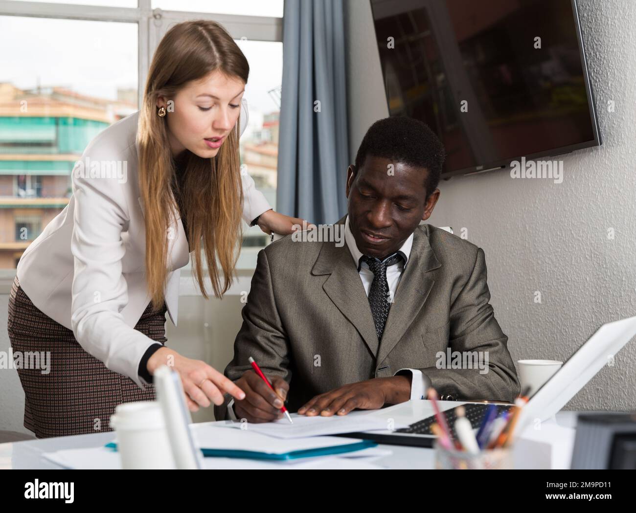 Young woman assistant having conversation with man boss during work ...