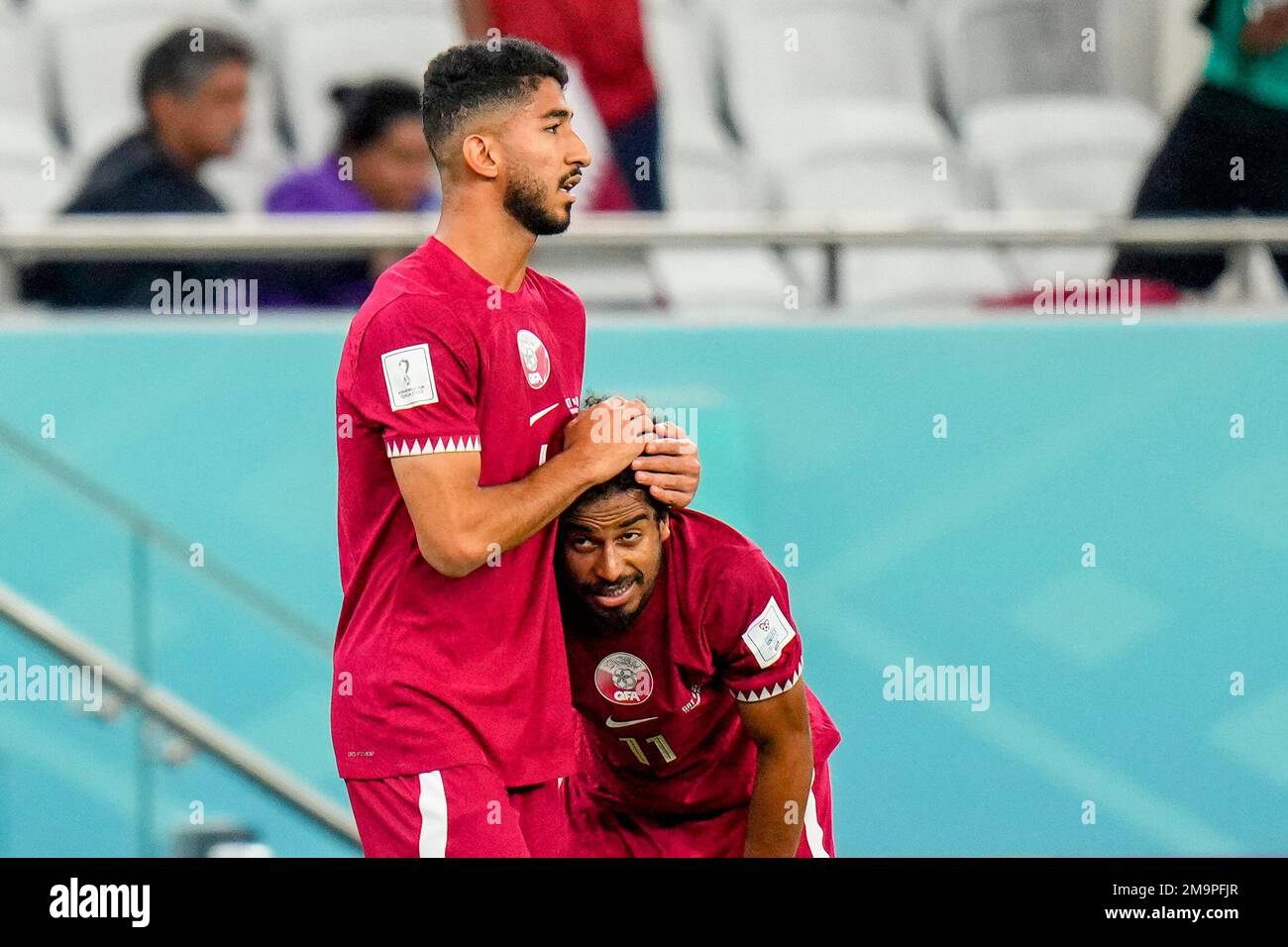 Qatar's Mohammed Waad embraces teammate Akram Afif after their 1-3 lost ...