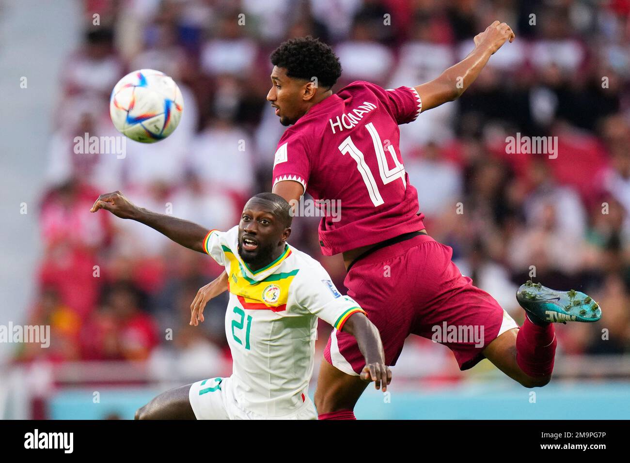 Qatar's Homam Ahmed (14) and Senegal's Iliman Ndiaye go for a header ...