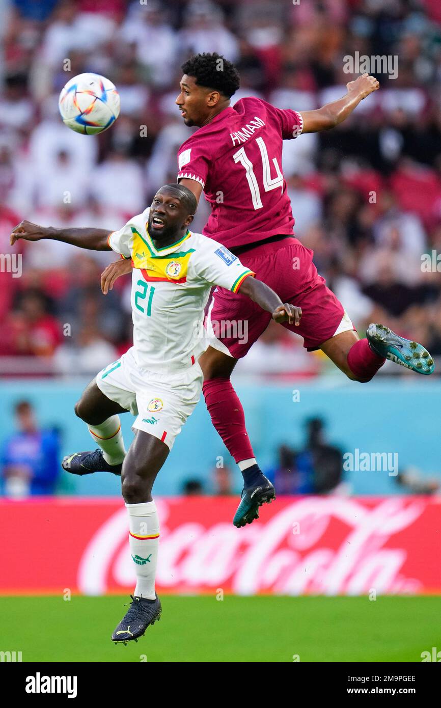 Qatar's Homam Ahmed (14) and Senegal's Iliman Ndiaye go for a header ...