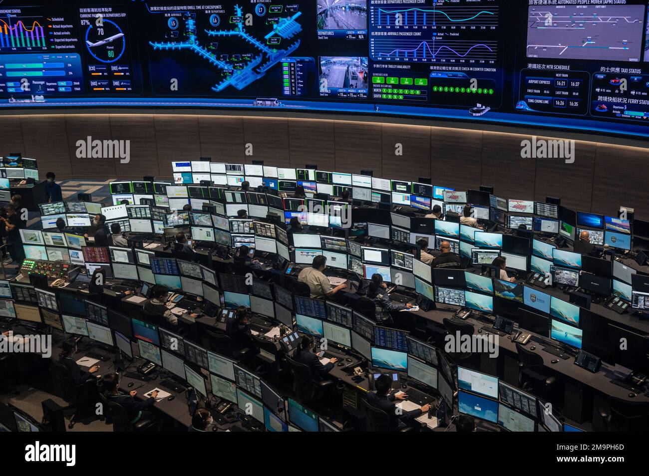 Workers monitor displays at the Integrated Airport Center at Hong Kong ...