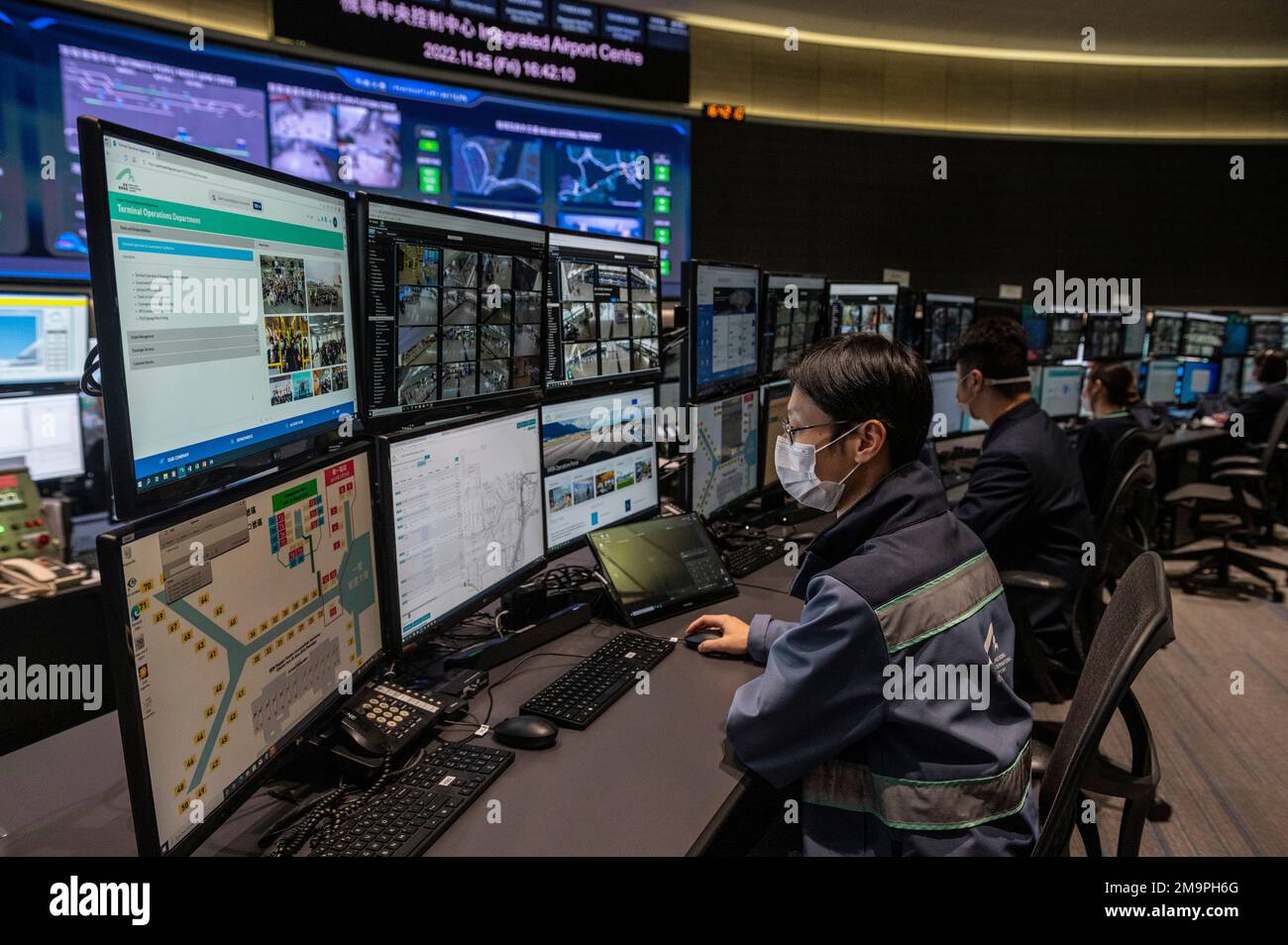 Workers monitor displays at the Integrated Airport Center at Hong Kong ...