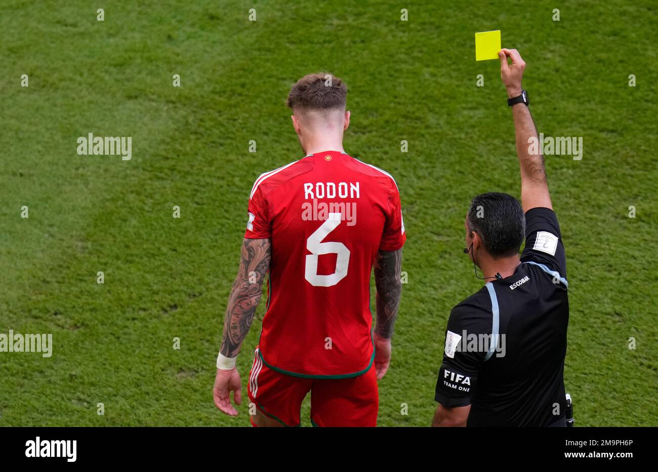 Referee Mario Alberto Escobar Toca shows a yellow card to Wales' Joe ...